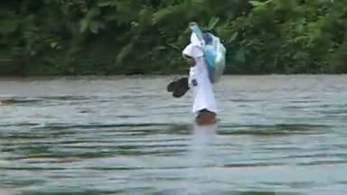 Children walk through a river to get to school